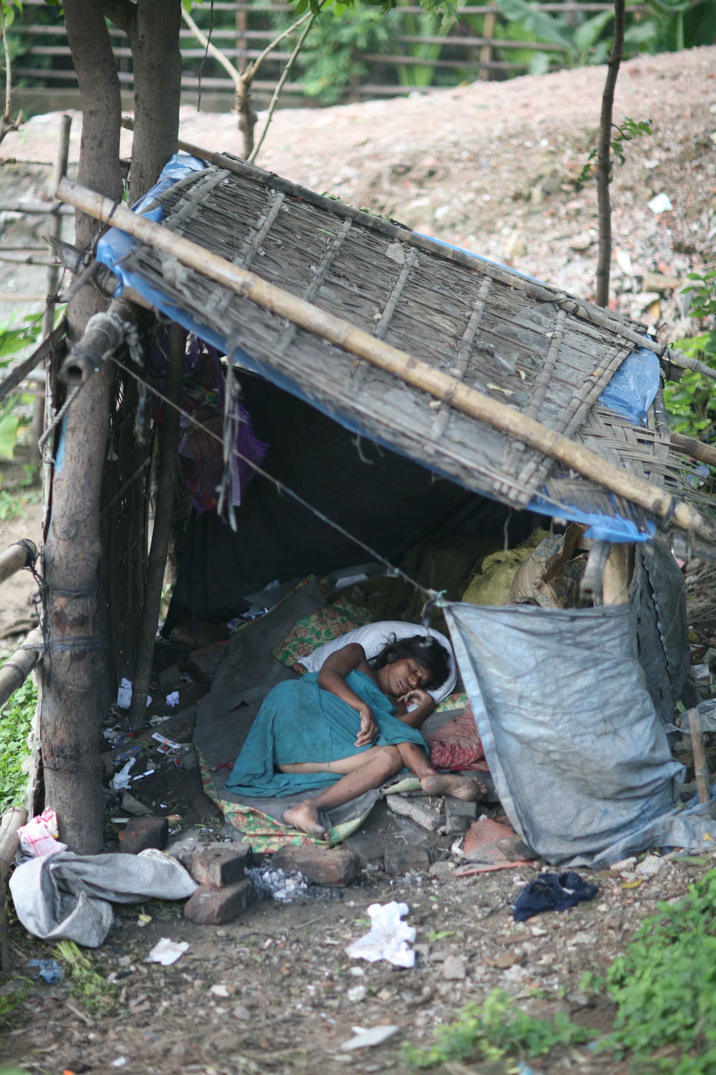 A woman sleeps in her makeshift shelter in one of Dhaka’s slums ...