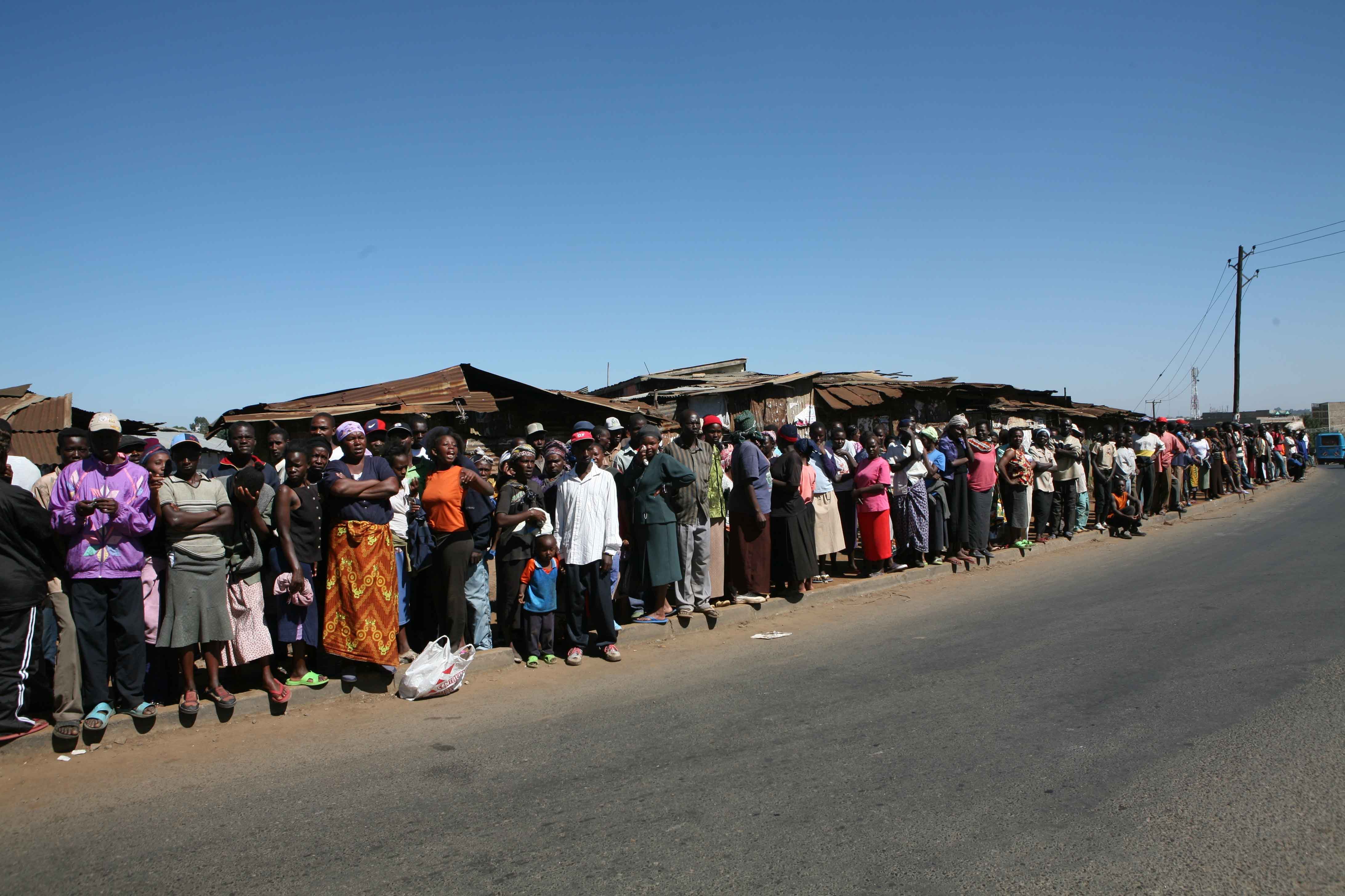 Residents queue up to receive food, in the Mathare slums, Nairobi ...