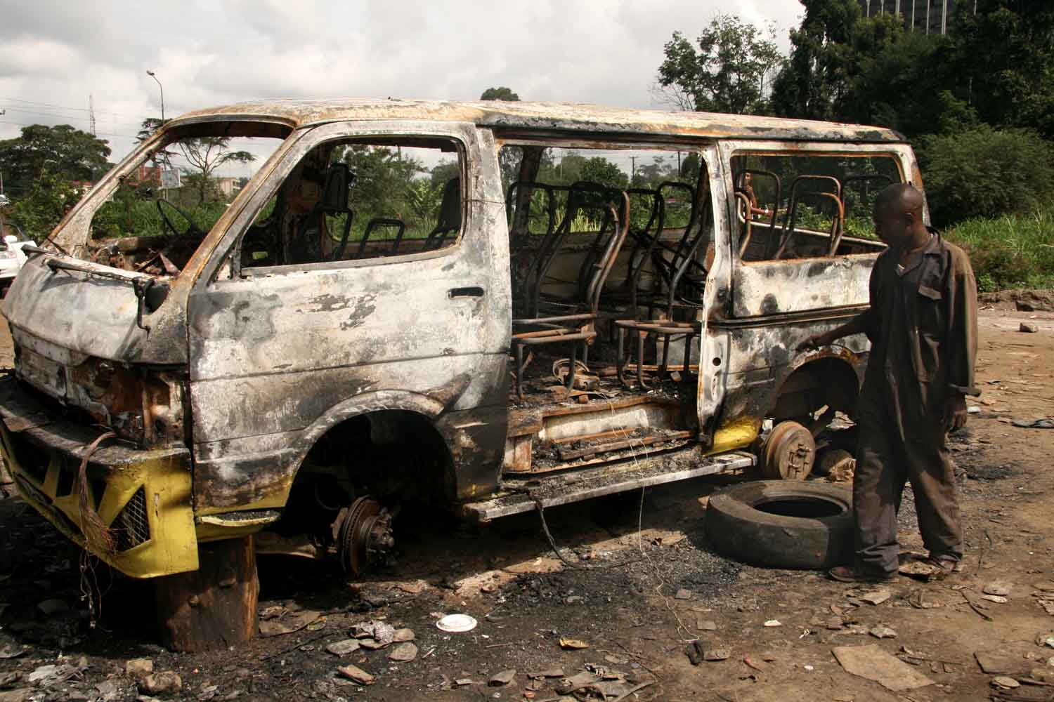 A man passes by a matatu that was set on fire by a group of suspected ...