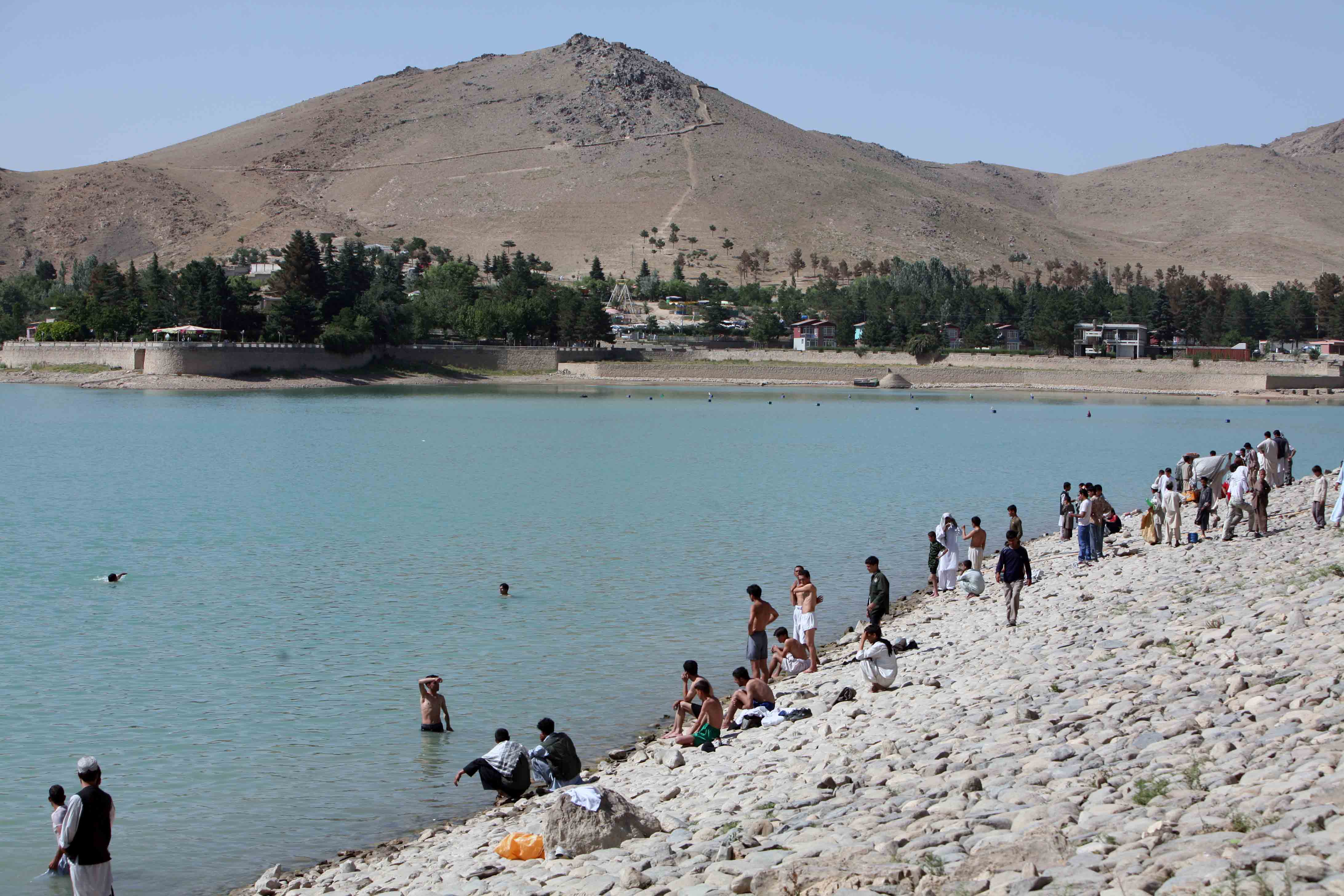 Residents of Kabul enjoy a hot summer day by Lake Qargha. Water is a ...