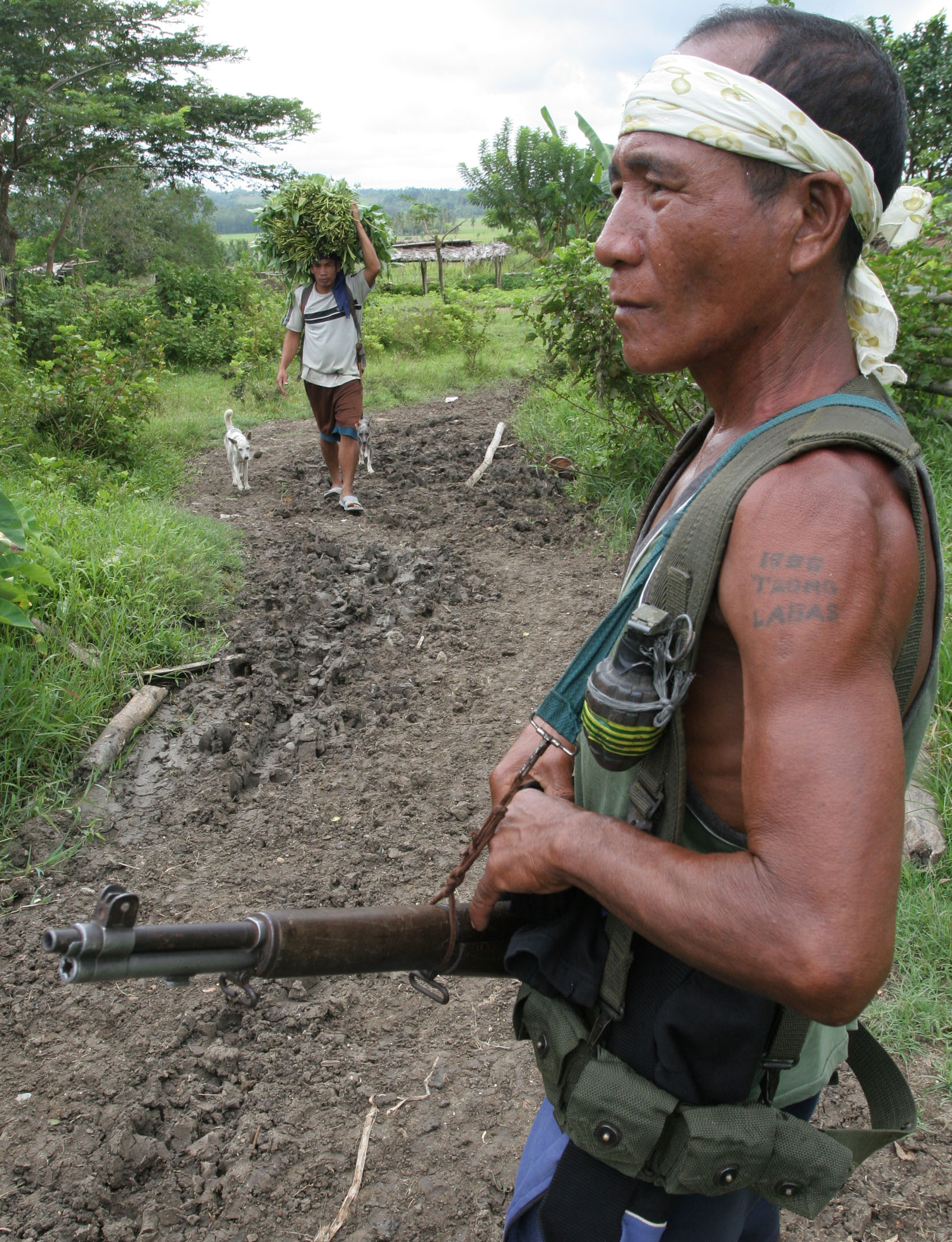 A member of a Christian militia group guards a roadside near a farming ...